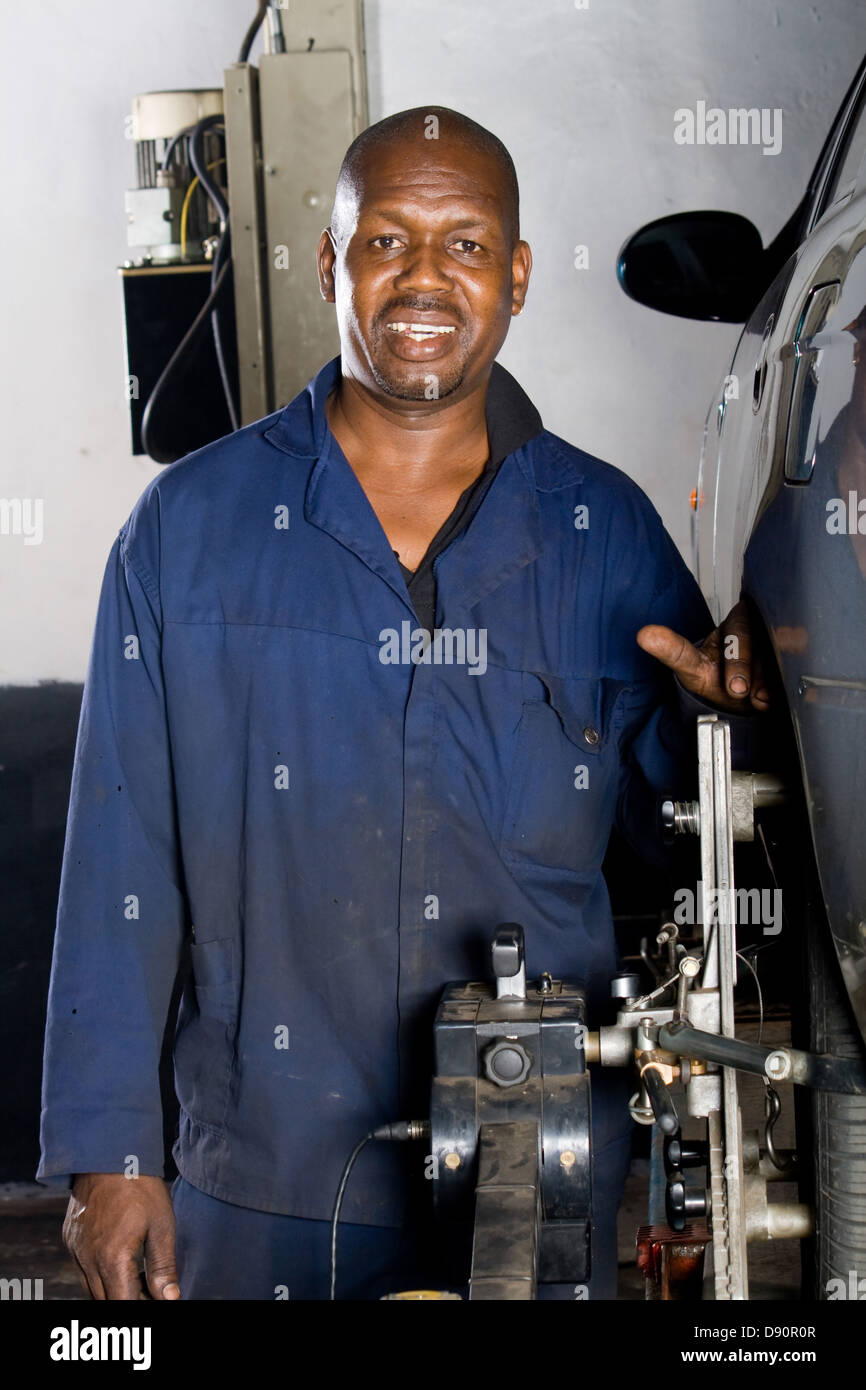african american auto mechanic working on a vehicle wheel alignment ...