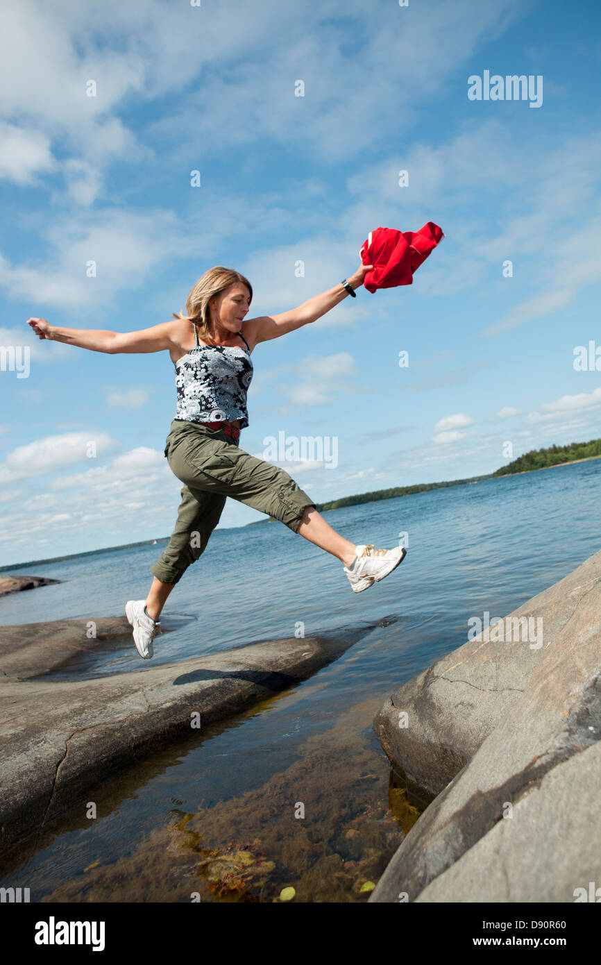Woman jumping over water Stock Photo - Alamy