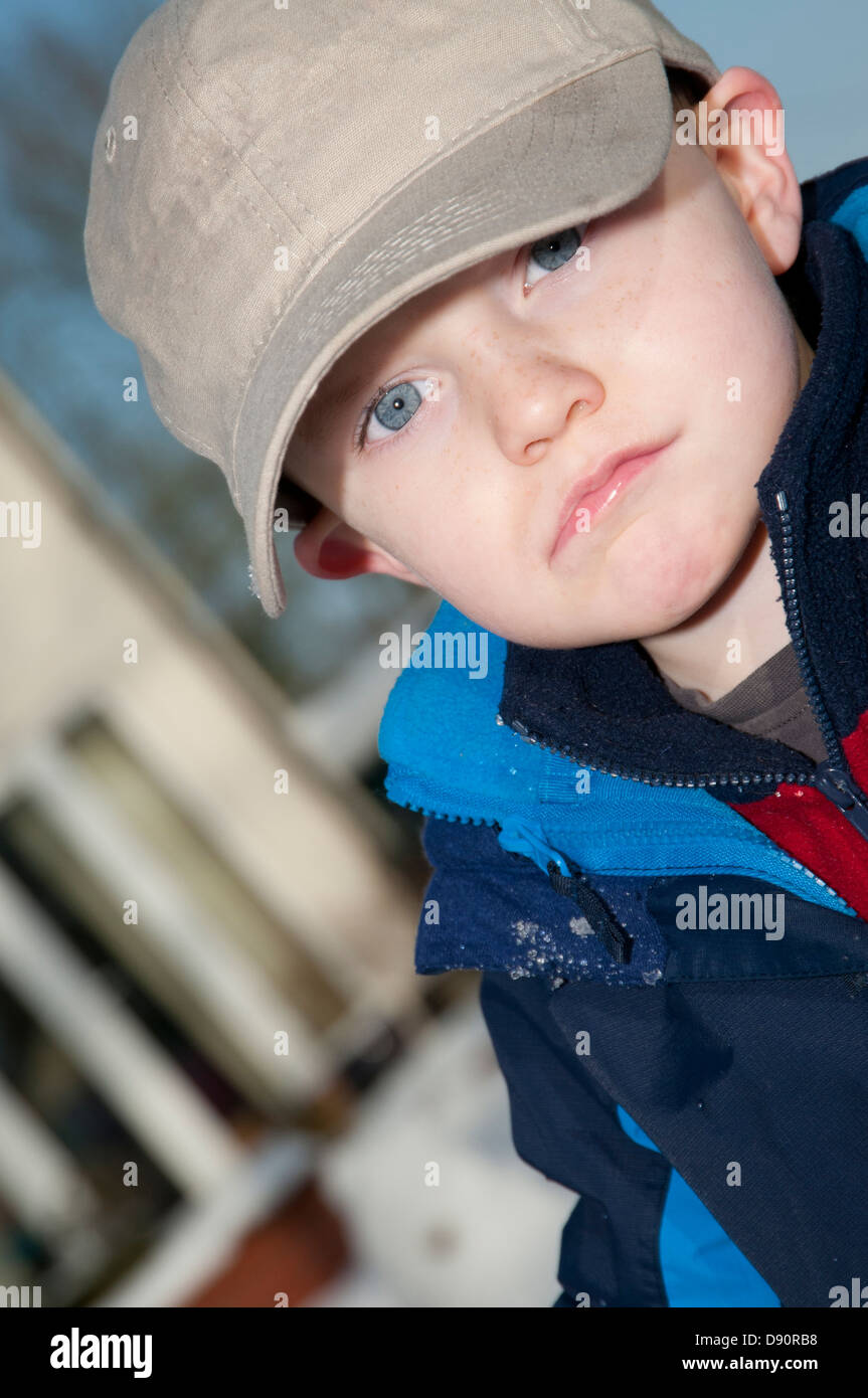 Young boy in coat and baseball cap Stock Photo - Alamy