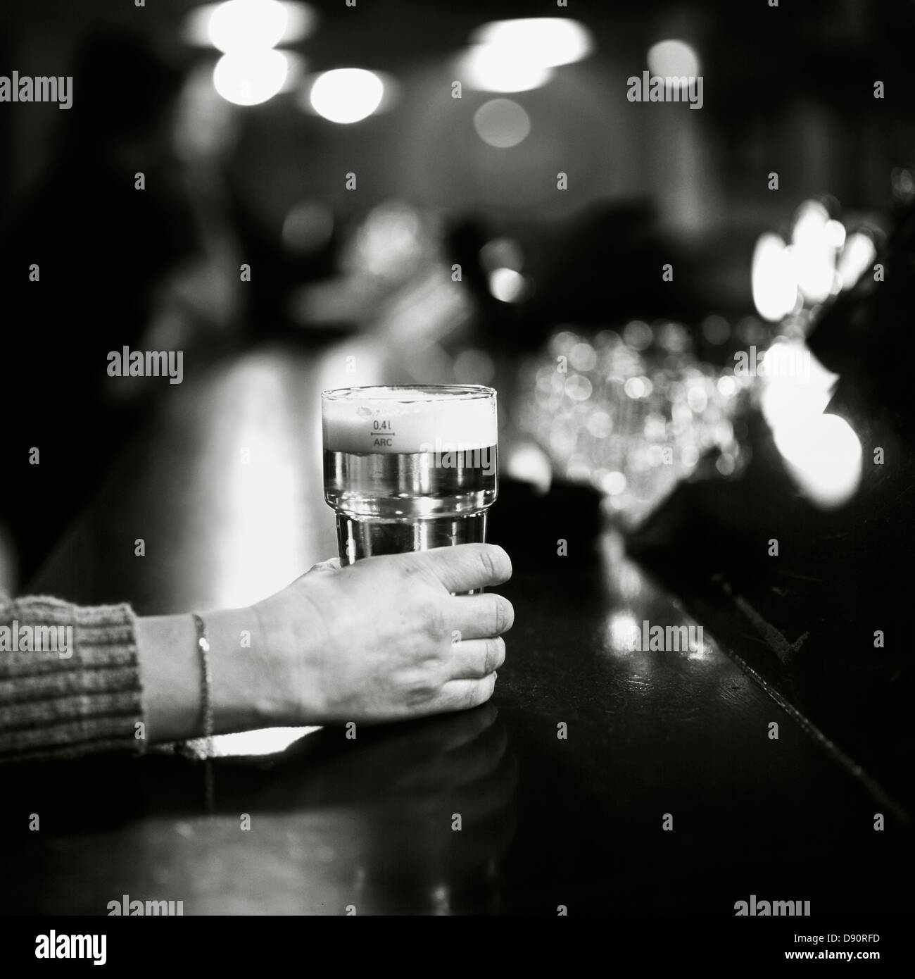 Hand of woman holding beer in bar Stock Photo - Alamy