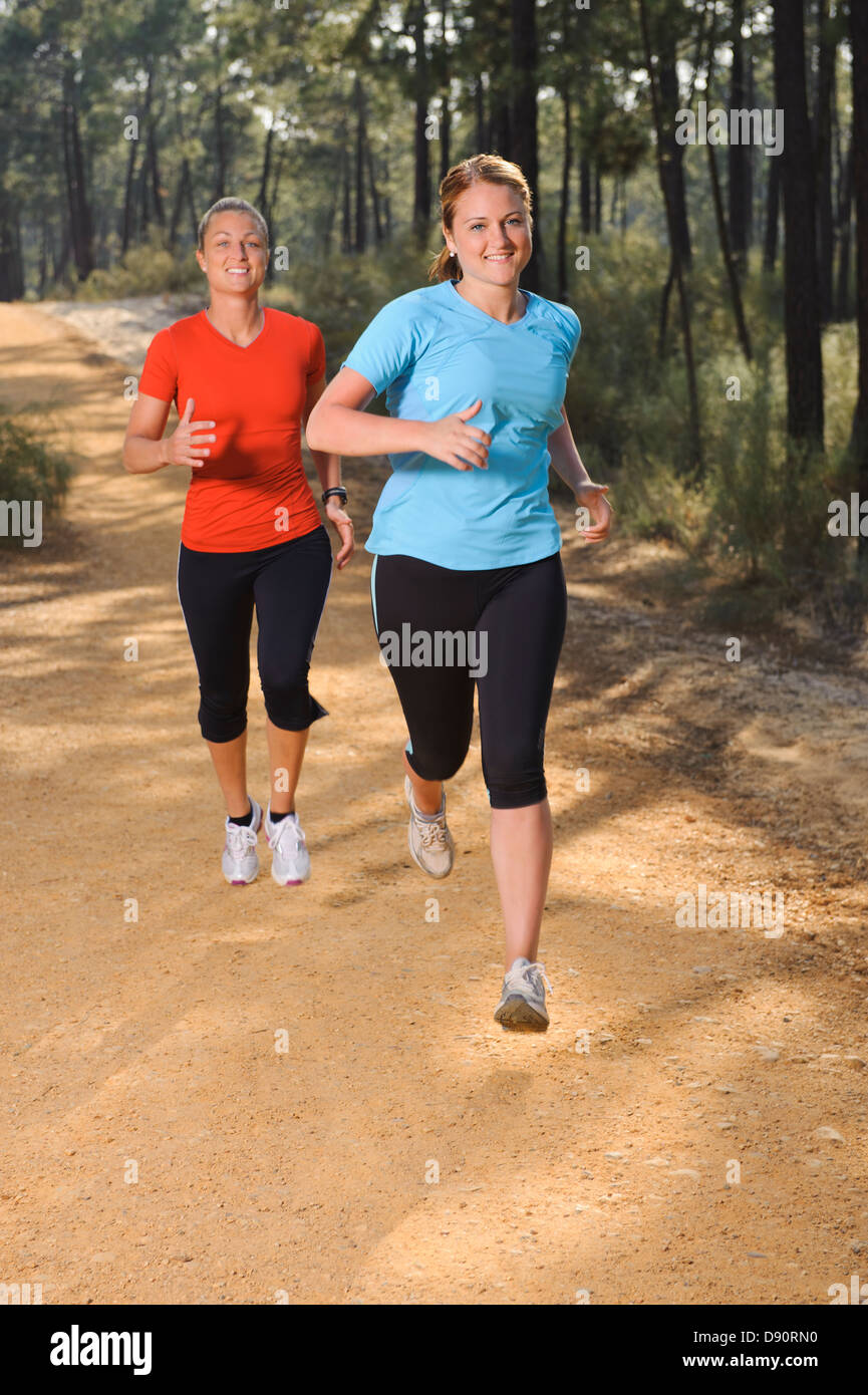 Two women jogging in forest Stock Photo - Alamy