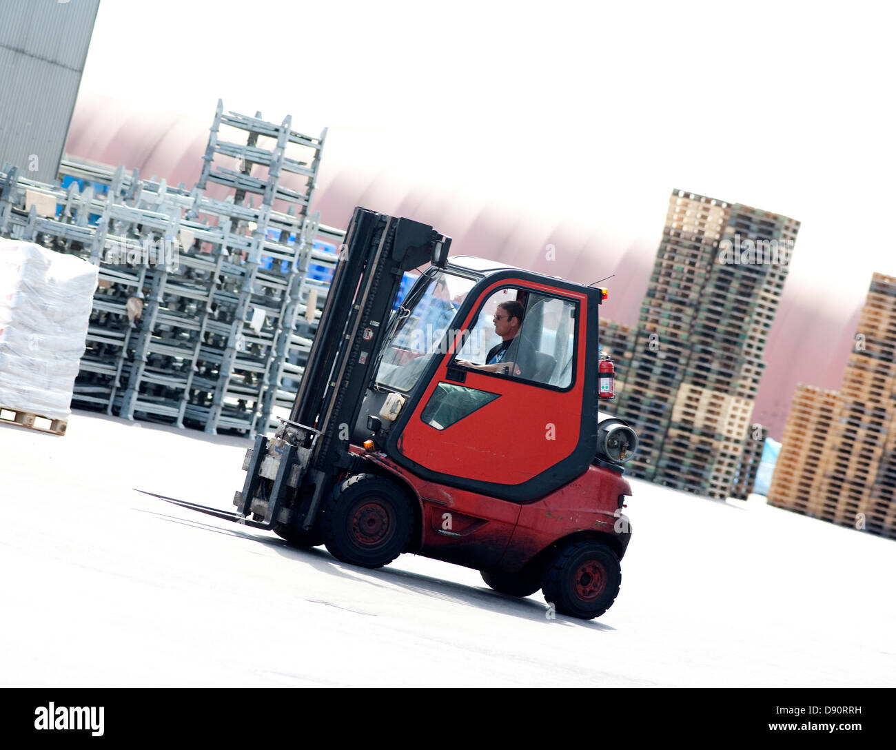 Forklift driving past pallets Stock Photo - Alamy