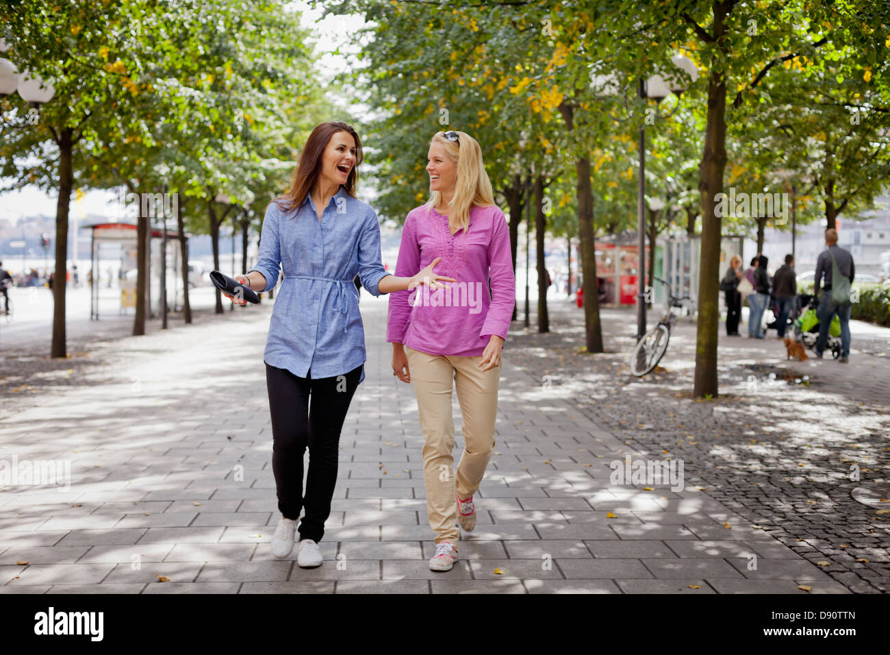 Two friends walking in park Stock Photo - Alamy