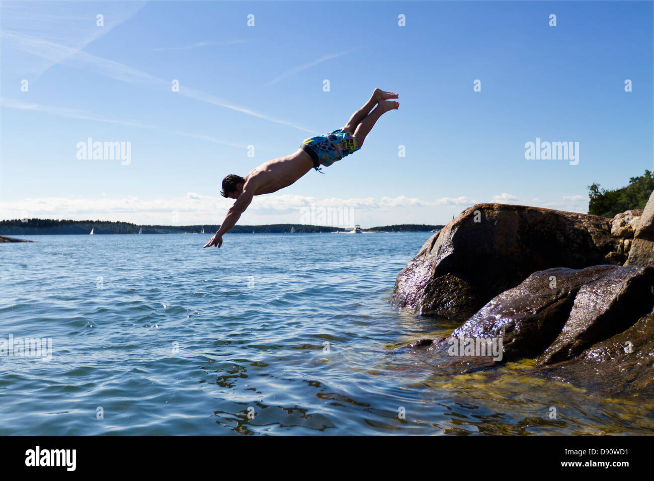 Young man jumping into water Stock Photo - Alamy