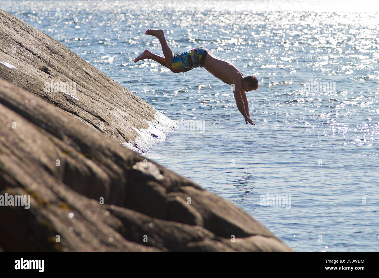 Young man jumping into water Stock Photo - Alamy