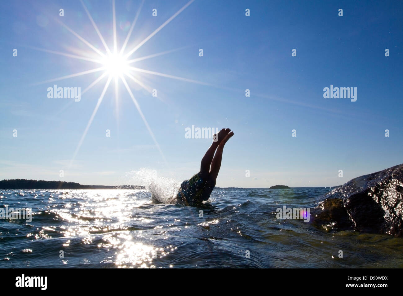 Young man jumping into water Stock Photo - Alamy