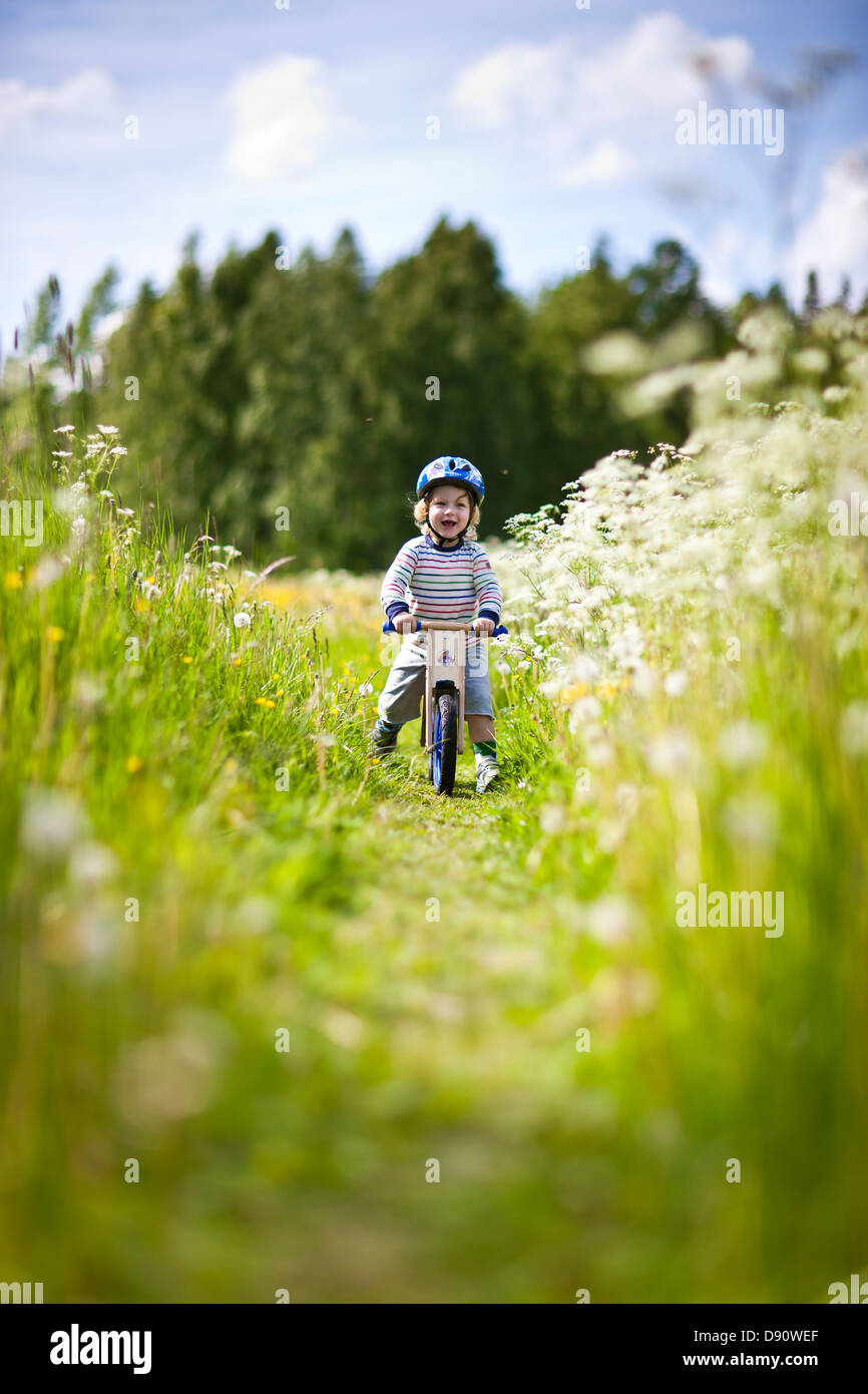 Boy cycling in meadow Stock Photo - Alamy