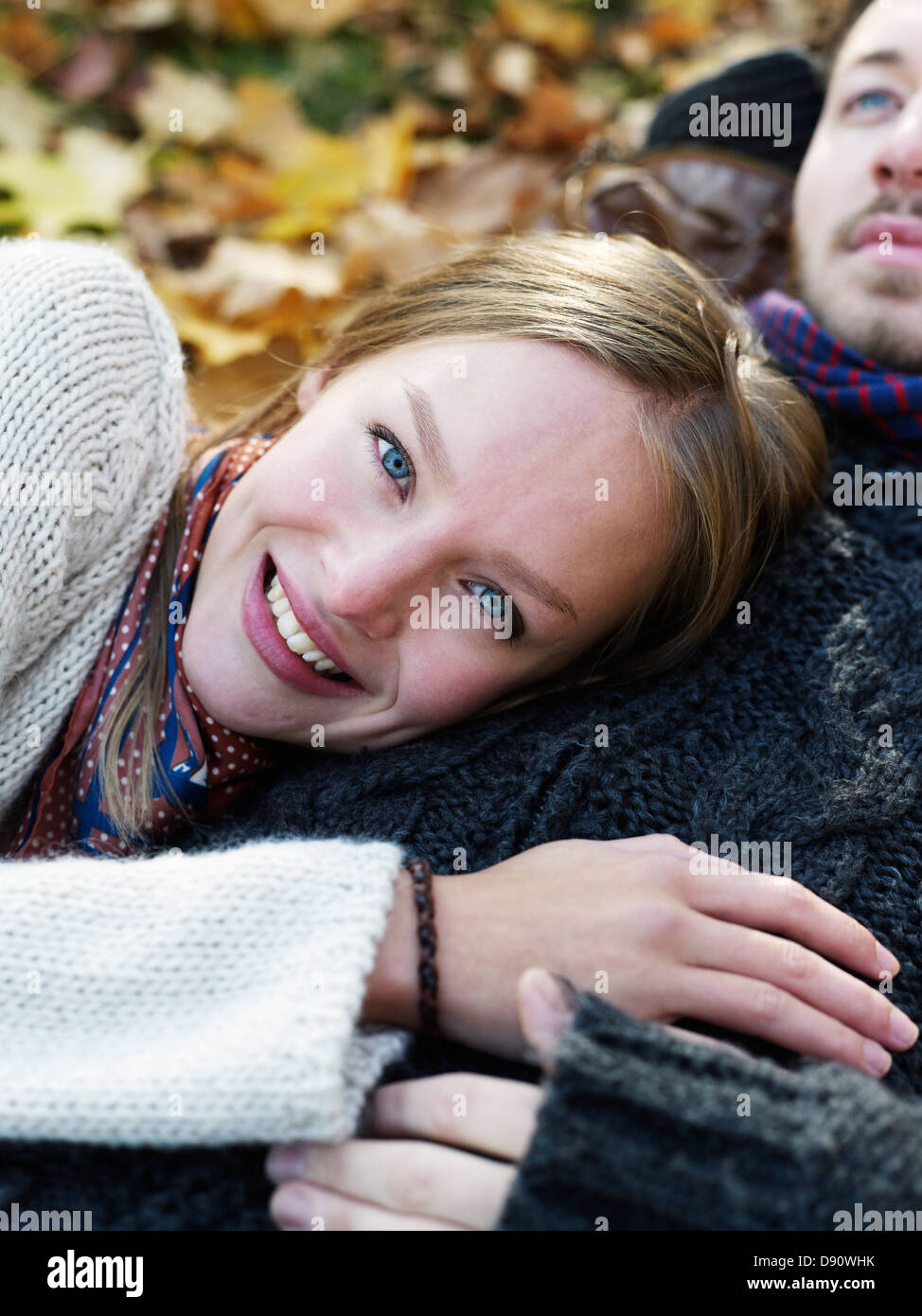 Portrait of young woman lying on man in leaves Stock Photo - Alamy