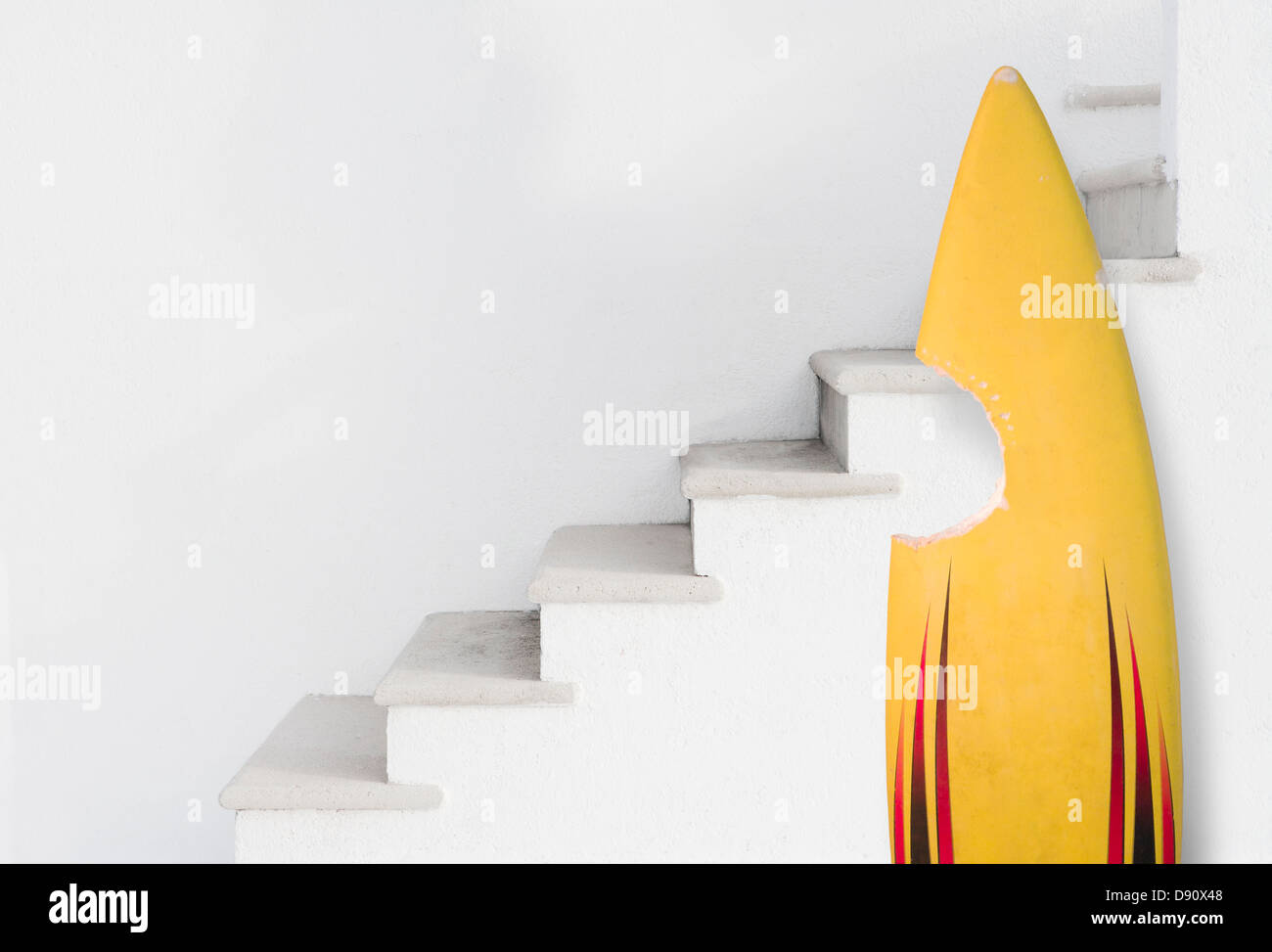 Damaged surfboard leaning against staircase Stock Photo - Alamy