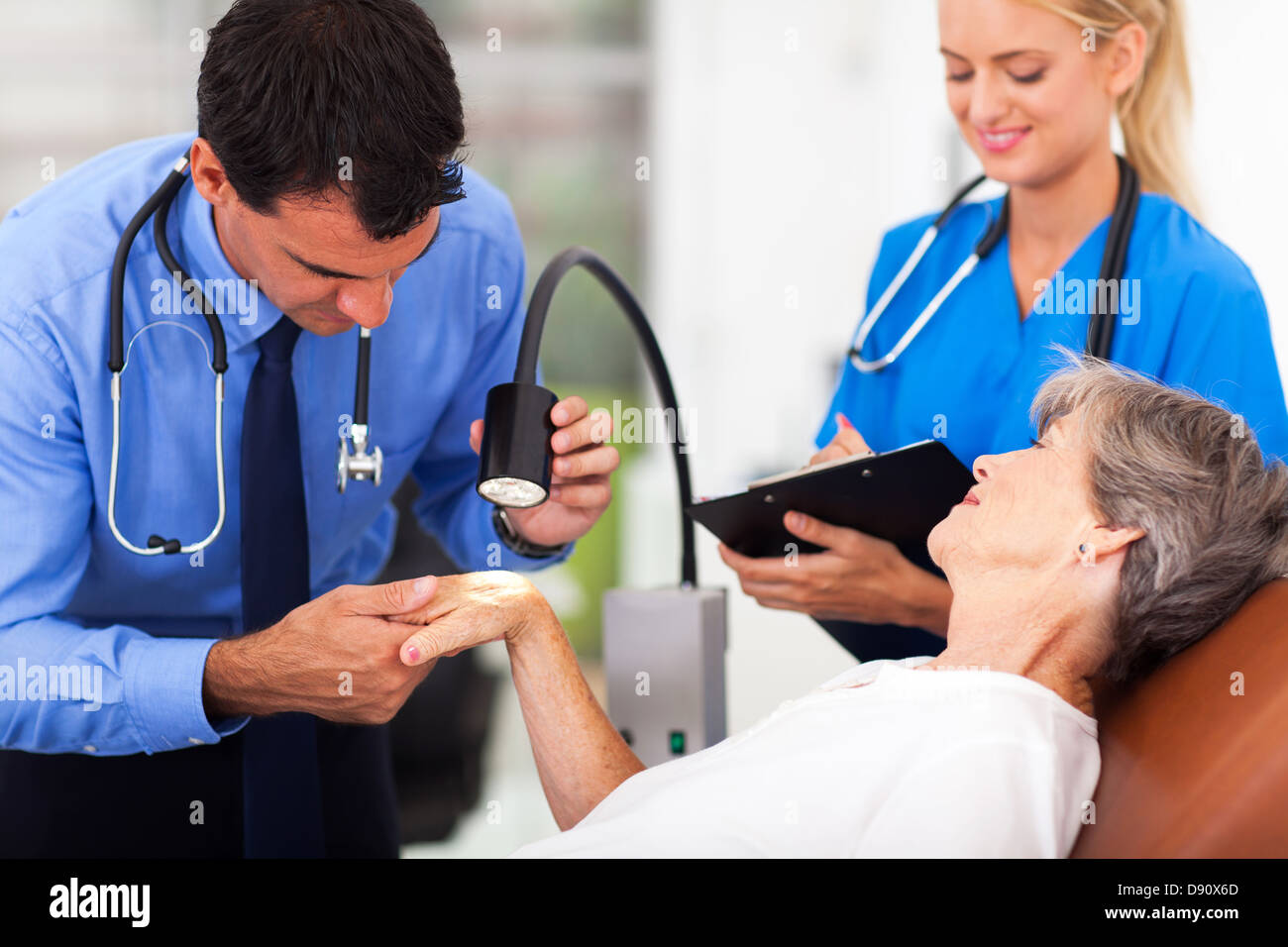Doctor examining senior womans skin hi-res stock photography and images ...