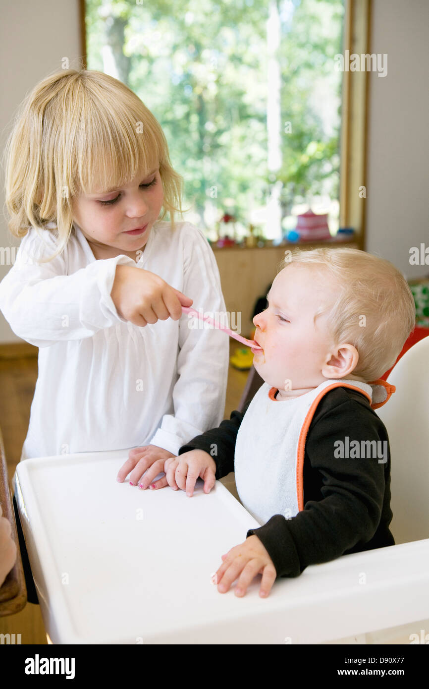 Sister giving food to little brother Stock Photo - Alamy