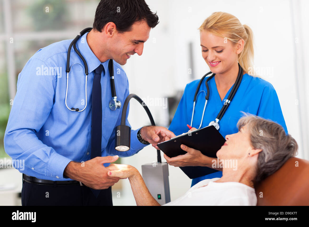 dermatologist and asssistant recording senior patient skin condition ... dermatologist and asssistant recording senior patient skin condition ...