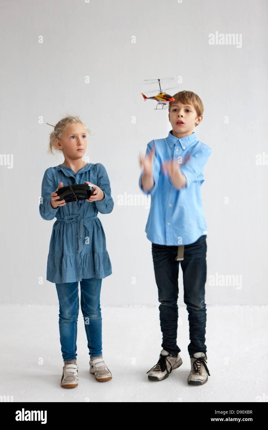 Boy and girl playing with helicopter model Stock Photo - Alamy