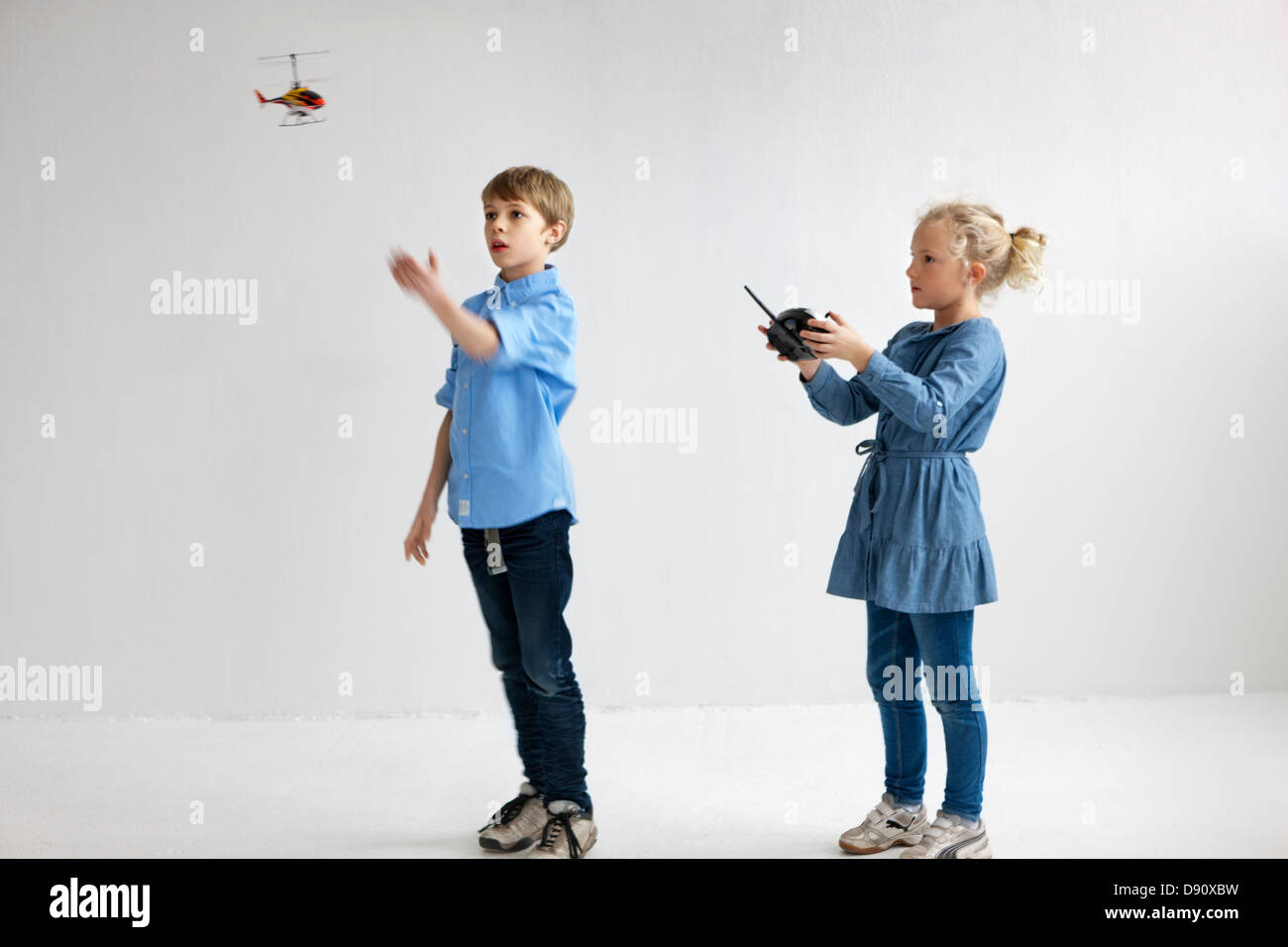 Boy and girl playing with helicopter model Stock Photo - Alamy
