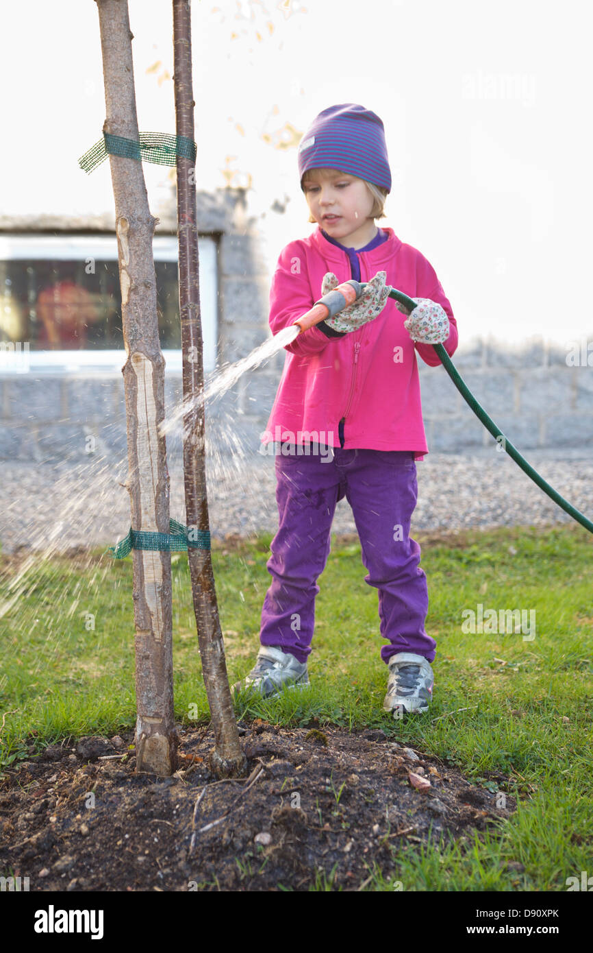 Girl watering tree Stock Photo - Alamy