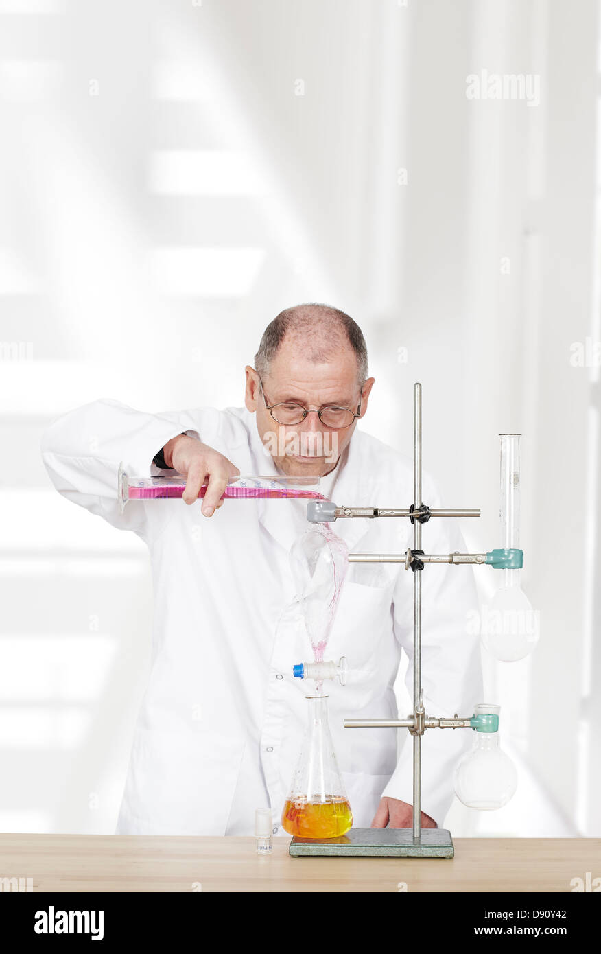 Scientist pouring chemical into beaker in laboratory Stock Photo - Alamy