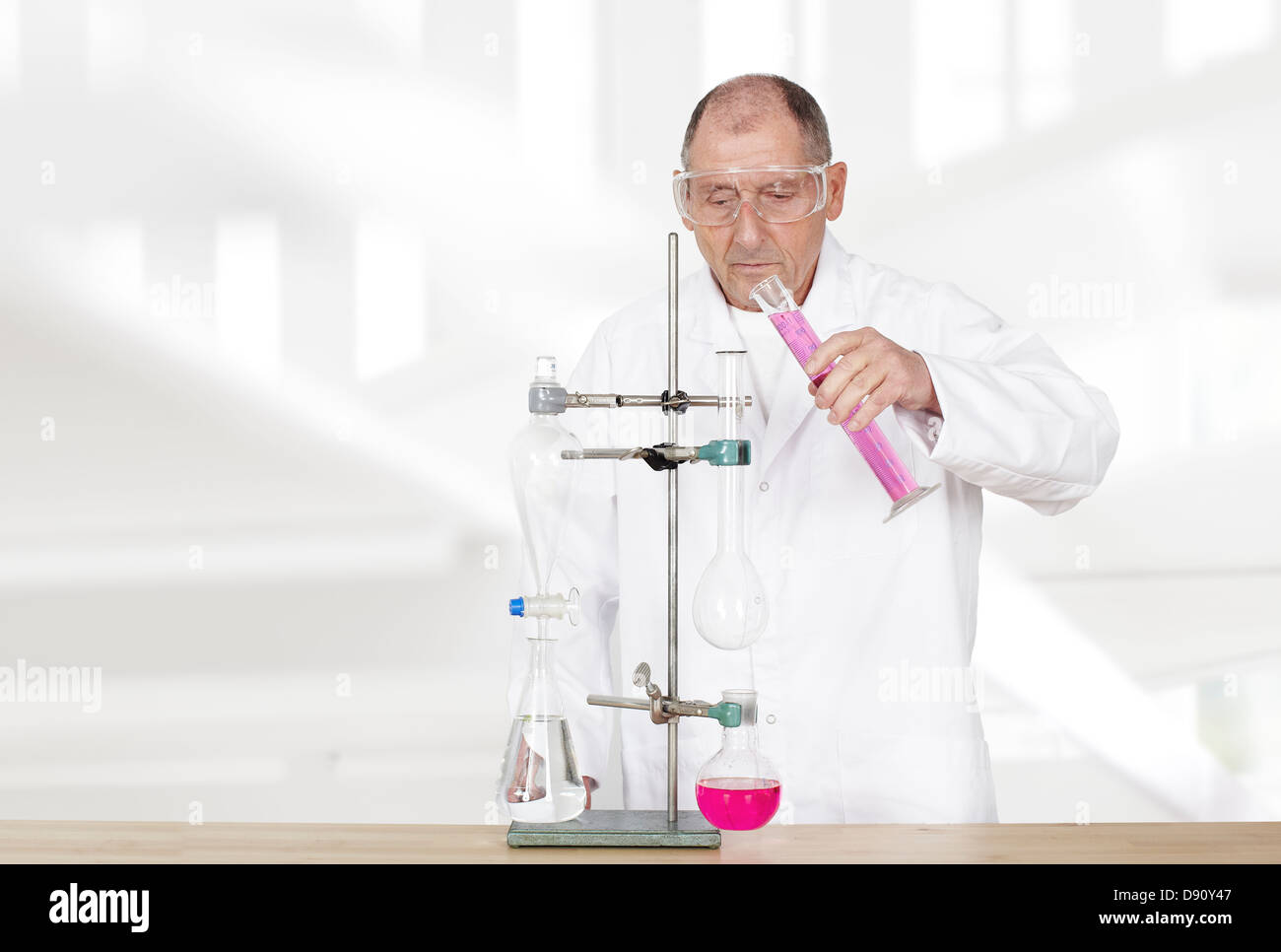Scientist pouring chemical into beaker in laboratory Stock Photo - Alamy