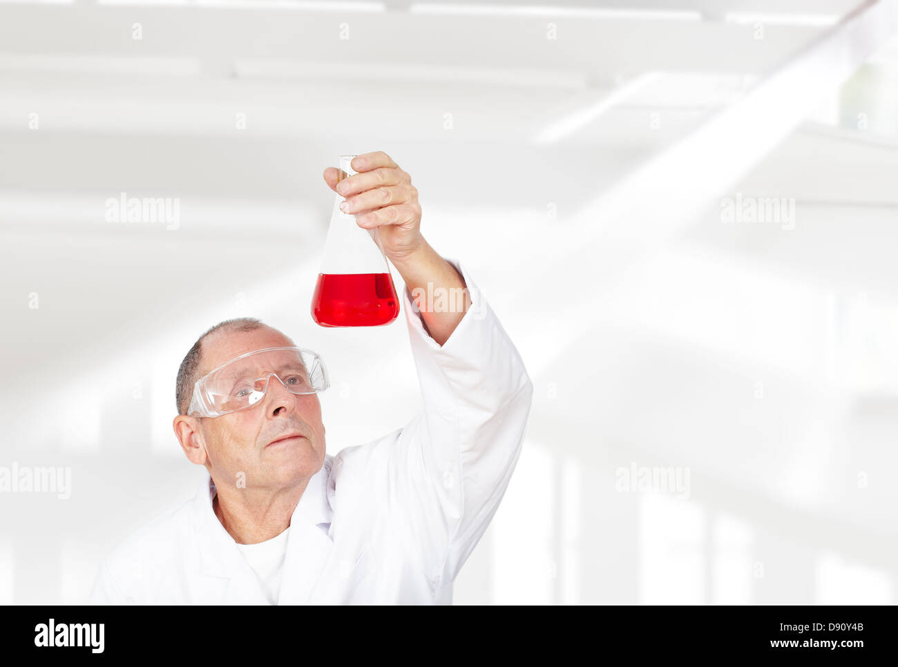 Scientist looking at beaker in laboratory Stock Photo - Alamy