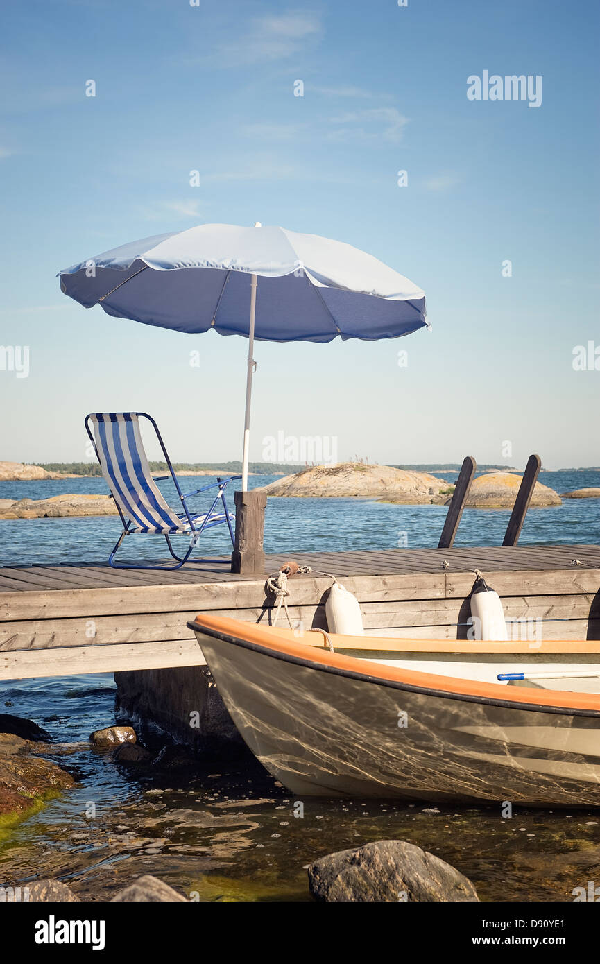 Deck chair and sunshade on jetty Stock Photo - Alamy
