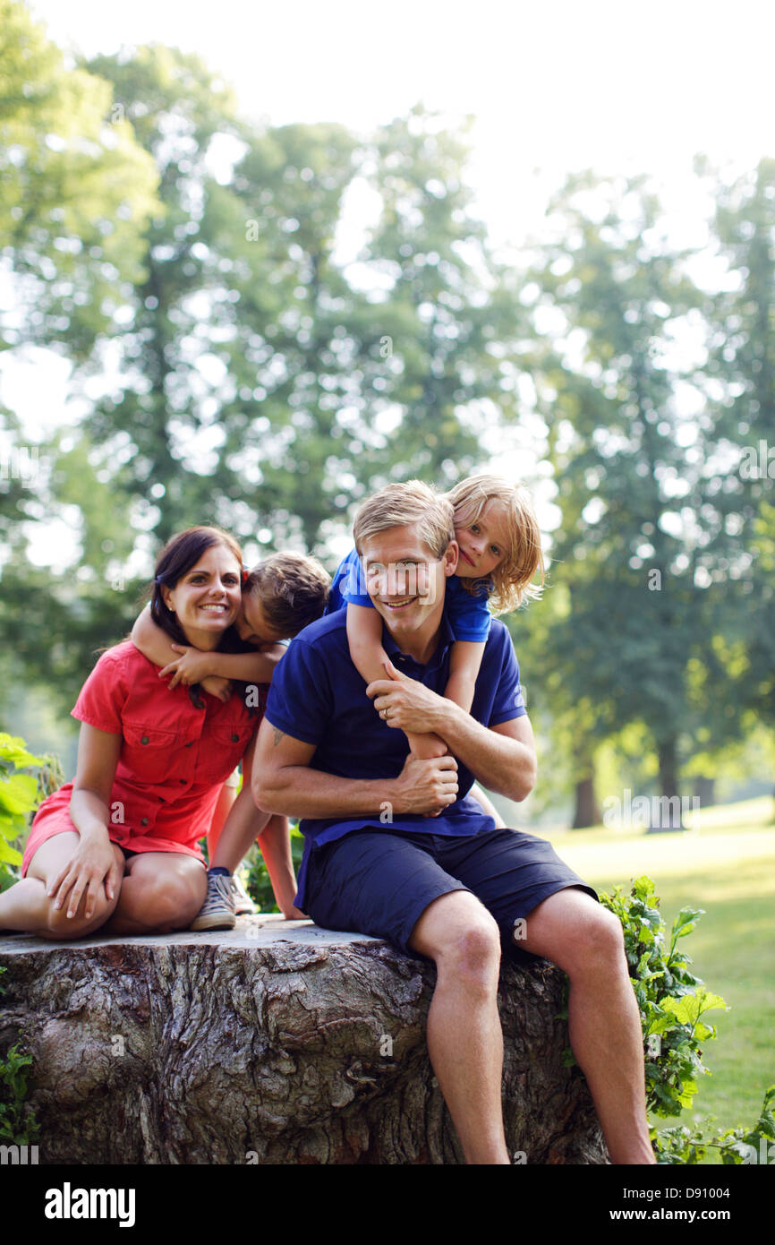 Family sitting on large tree stump in park Stock Photo - Alamy