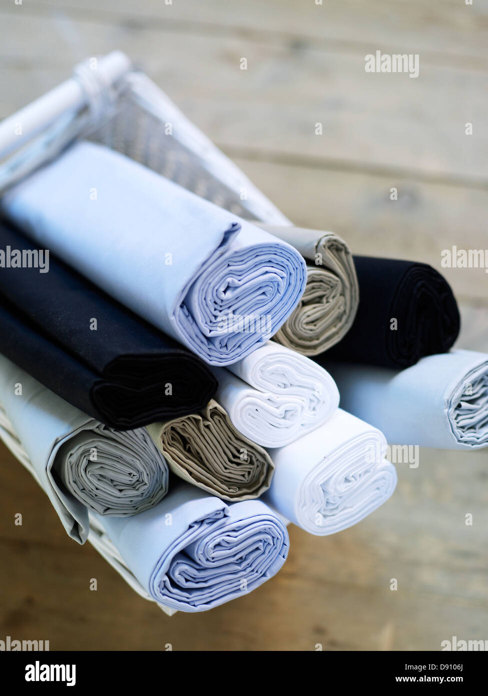 Rolled up bed sheets in basket Stock Photo - Alamy