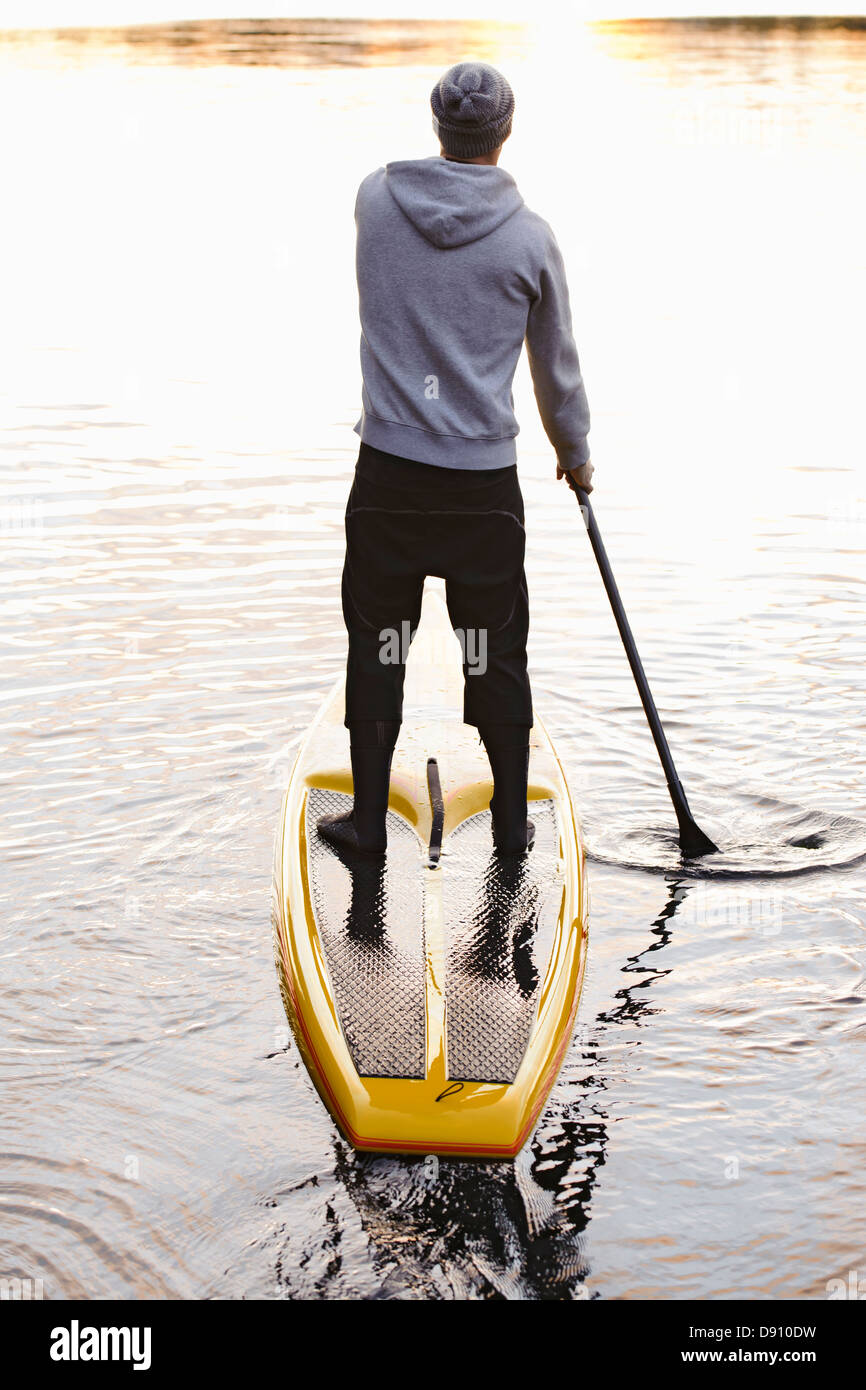 Man rowing paddle board in water, rear view Stock Photo - Alamy