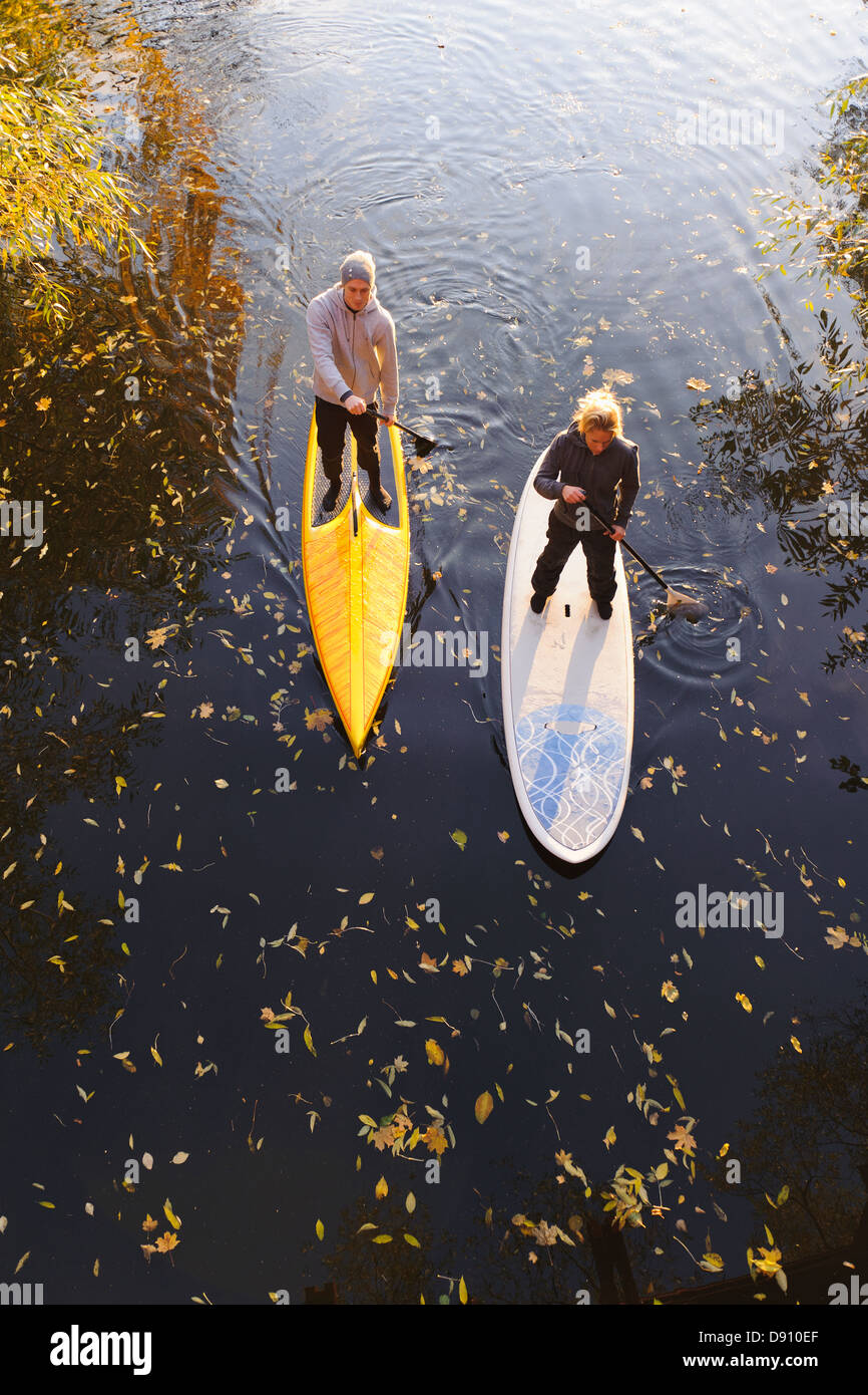 Two people rowing paddle boards in autumn trees, elevated view Stock ...