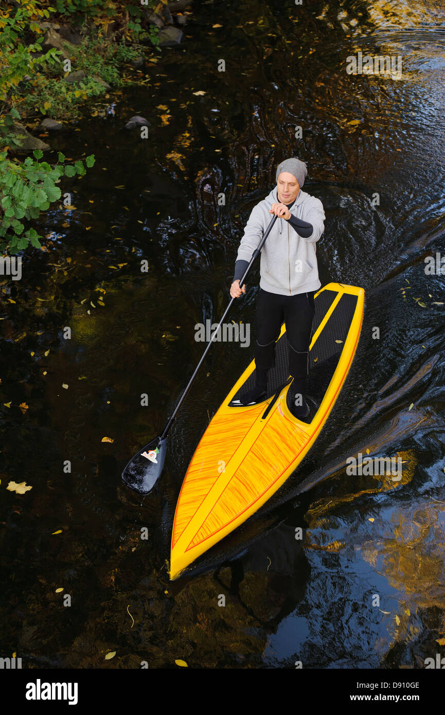 Man rowing paddle board in water Stock Photo - Alamy