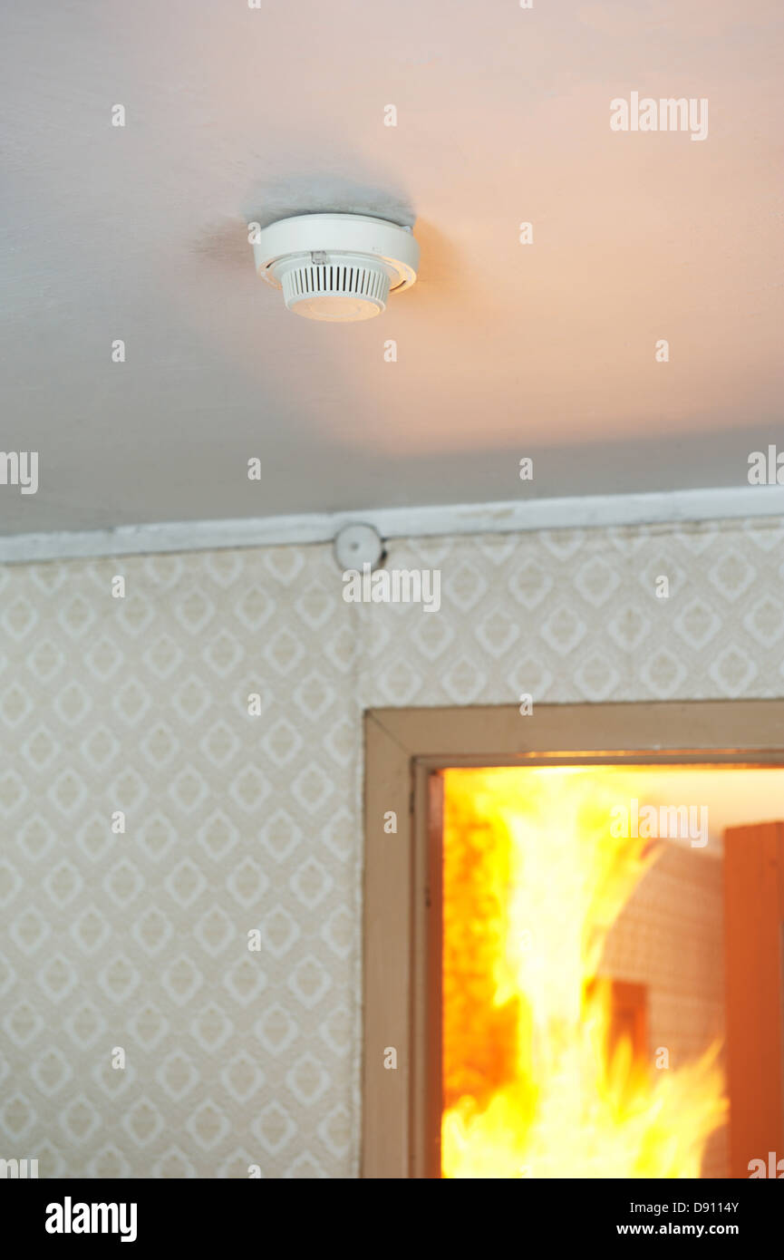 Home smoke detector, fire in background Stock Photo - Alamy