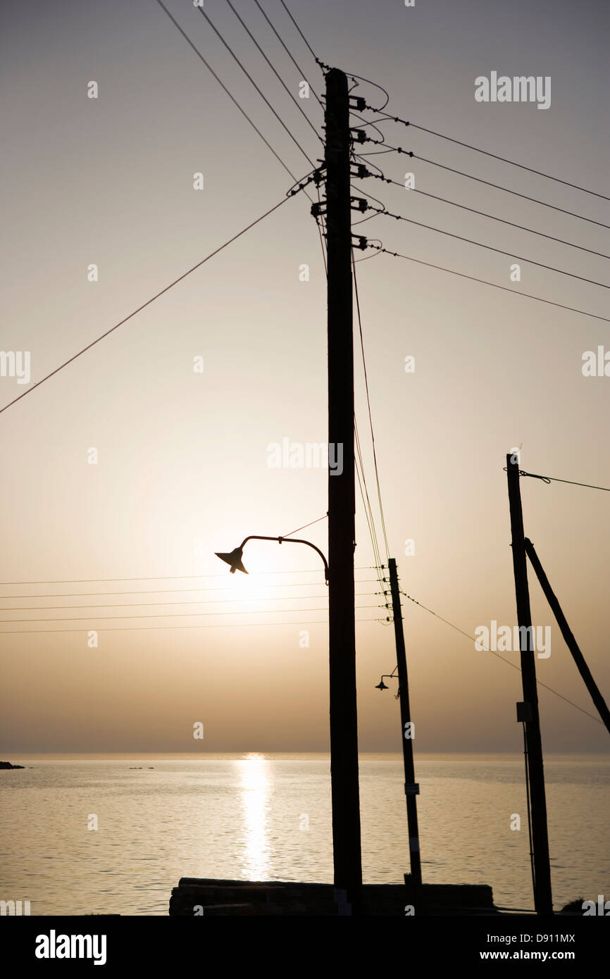 Electric lines in the sunset by the sea, Greece Stock Photo - Alamy