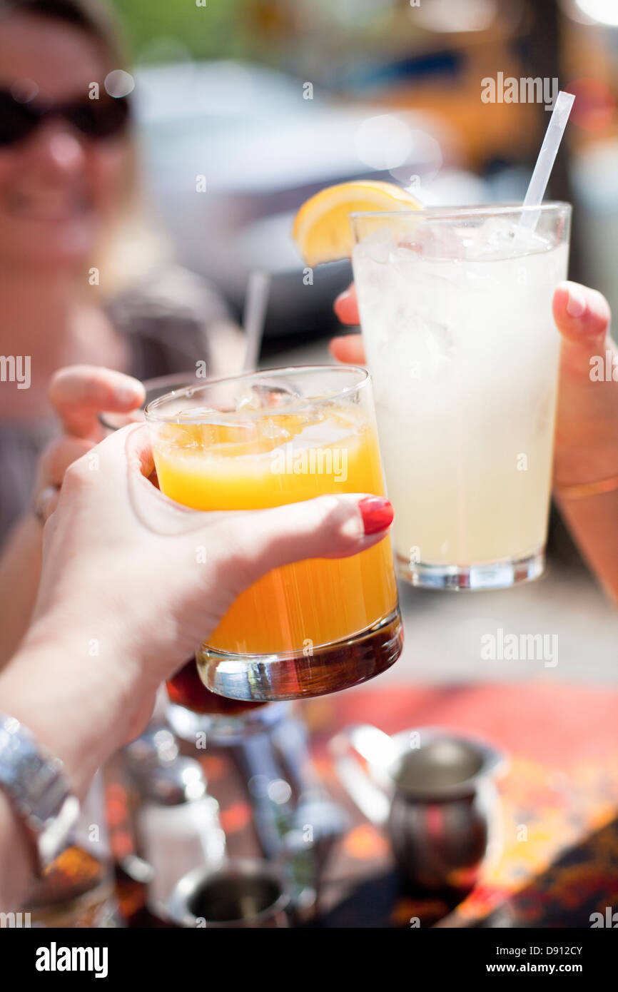 Womens hands holding cocktails Stock Photo - Alamy
