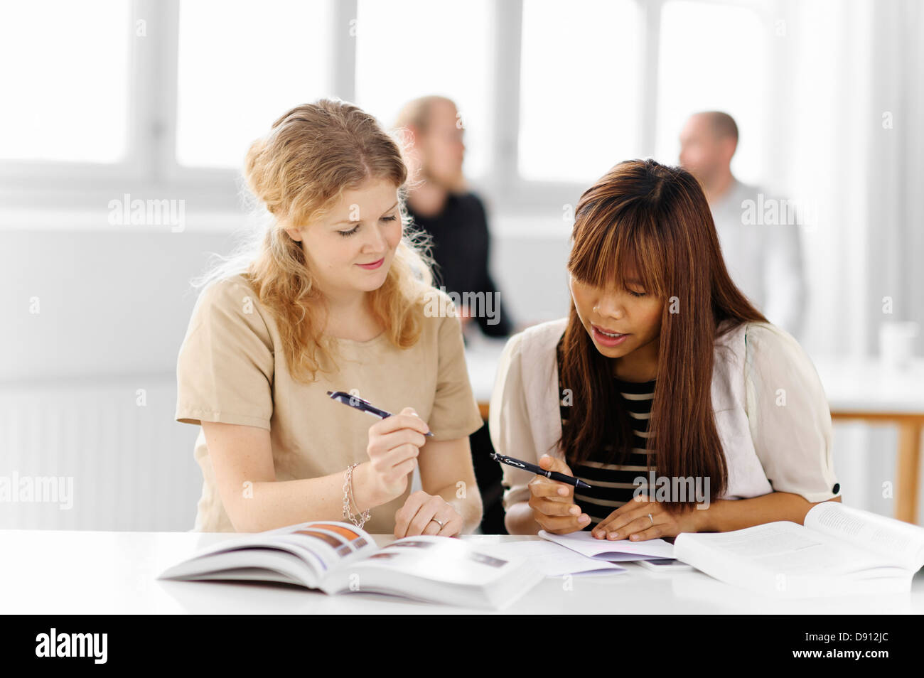 Two female students studying in library Stock Photo - Alamy