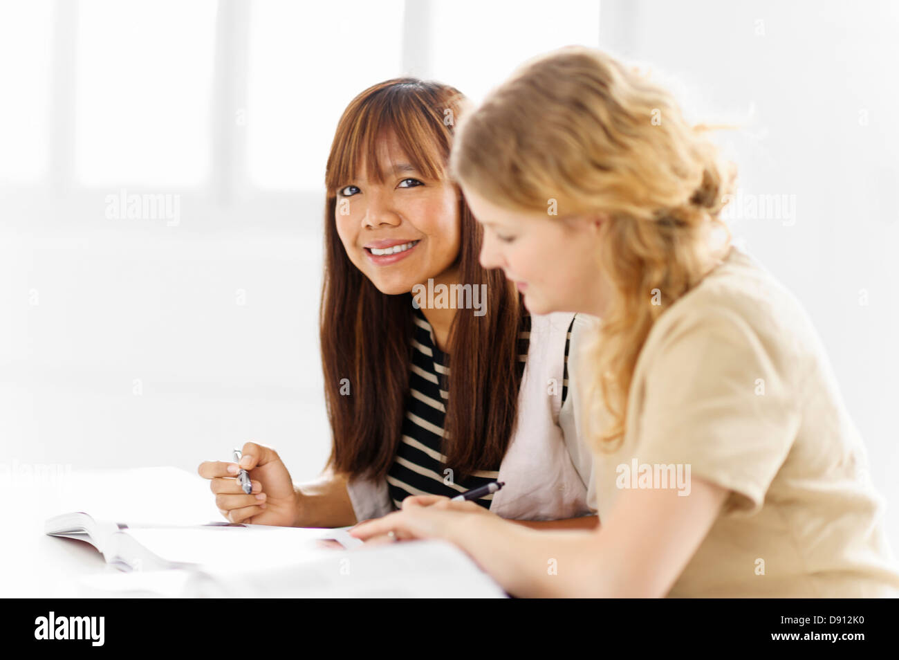 Two female students studying in library Stock Photo - Alamy