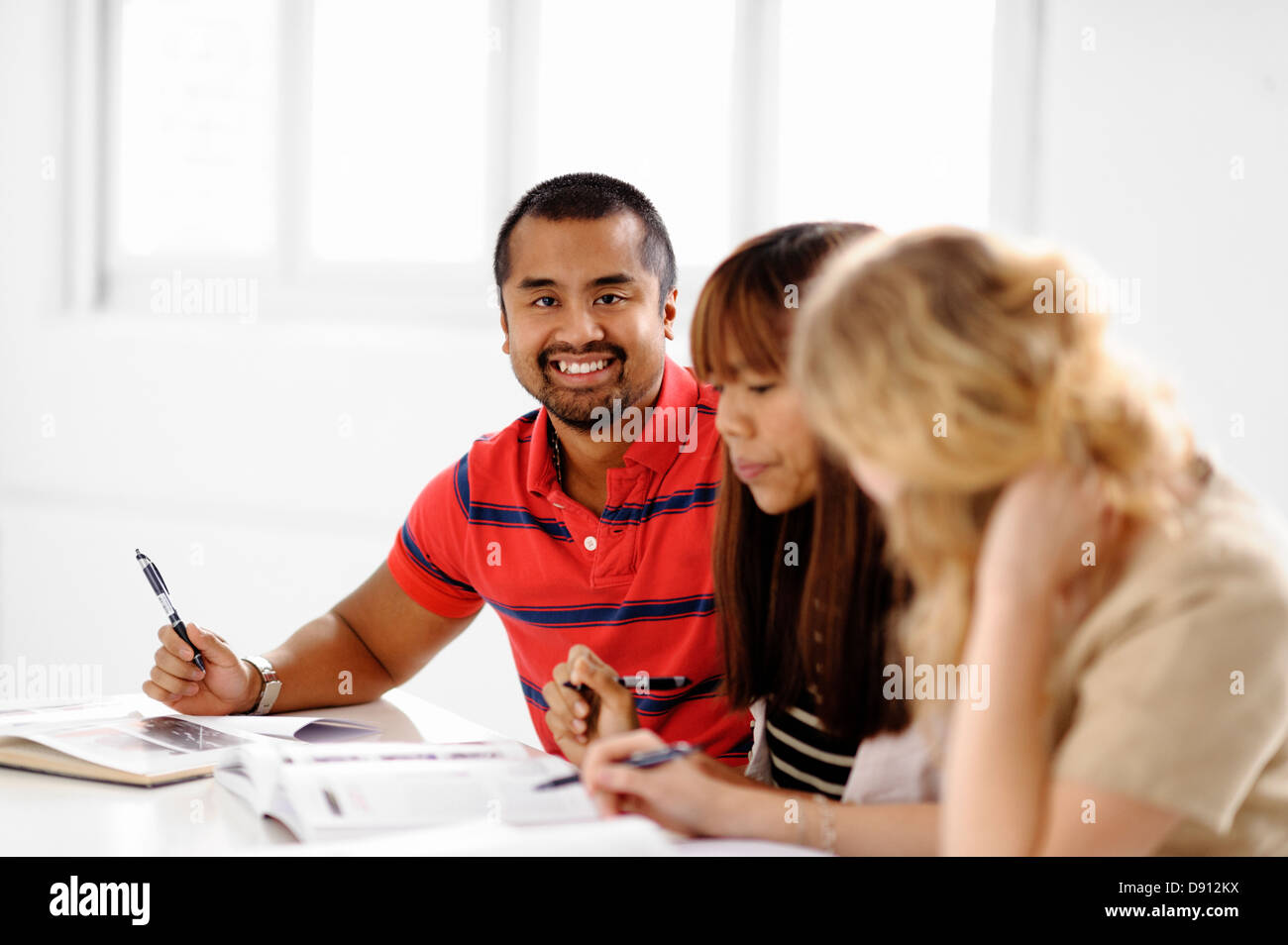 Happy students studying in library Stock Photo - Alamy