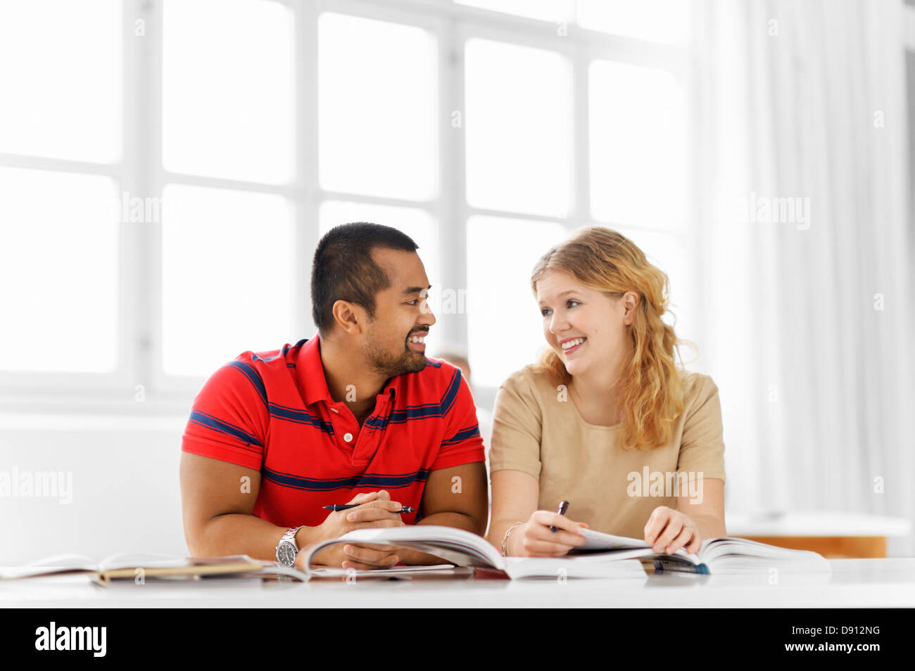 Happy students studying in library Stock Photo - Alamy