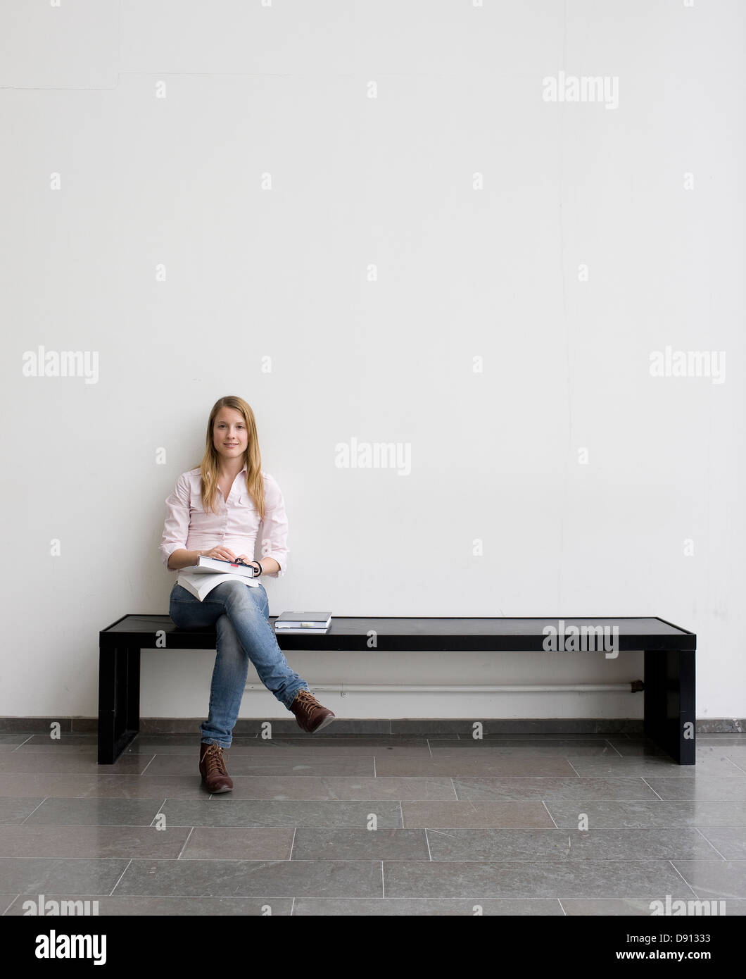 Young student sitting on bench Stock Photo - Alamy