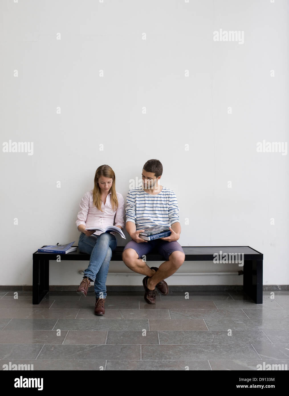 Young students sitting on bench Stock Photo - Alamy
