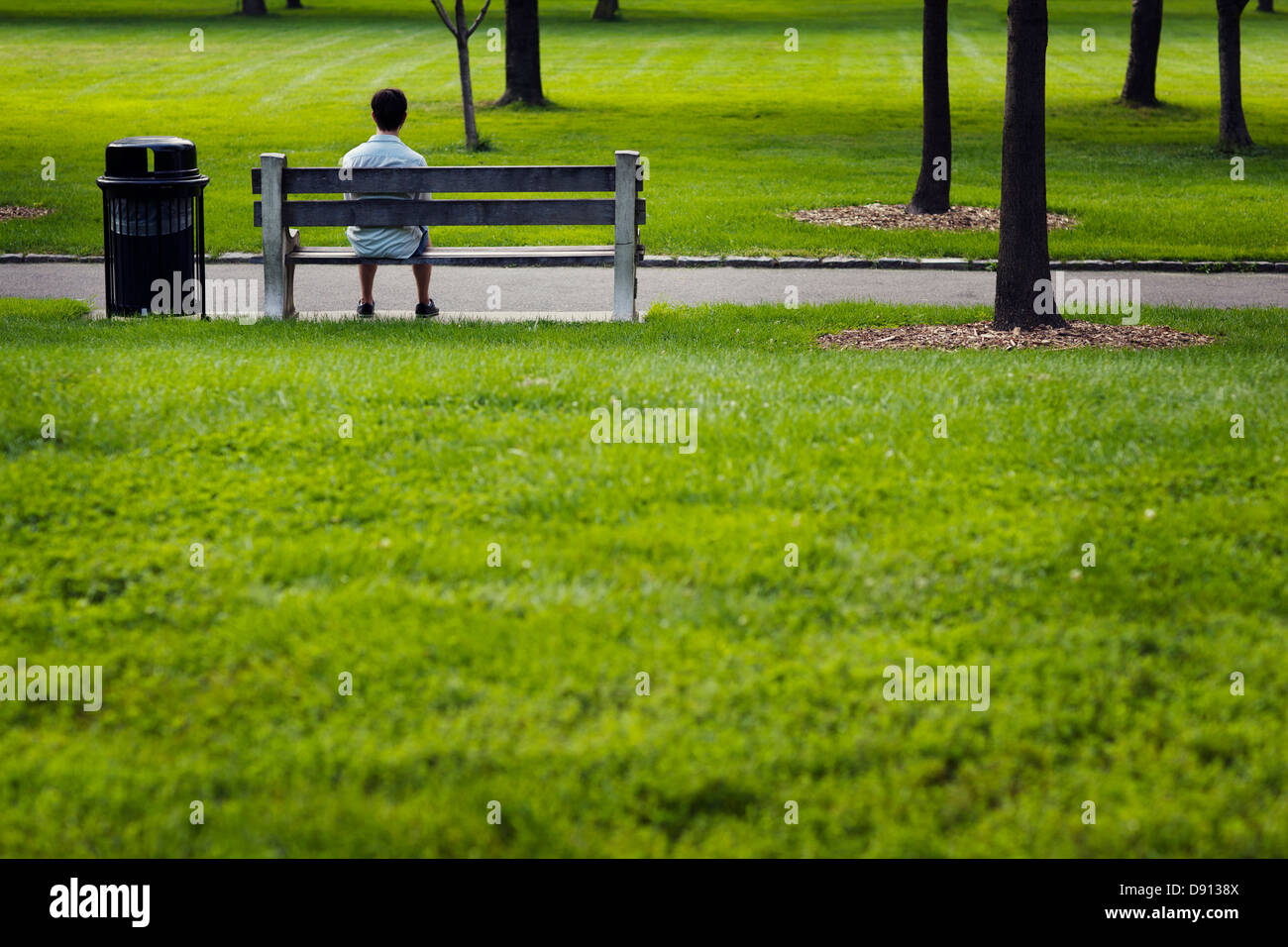 Man sitting on bench in park Stock Photo - Alamy