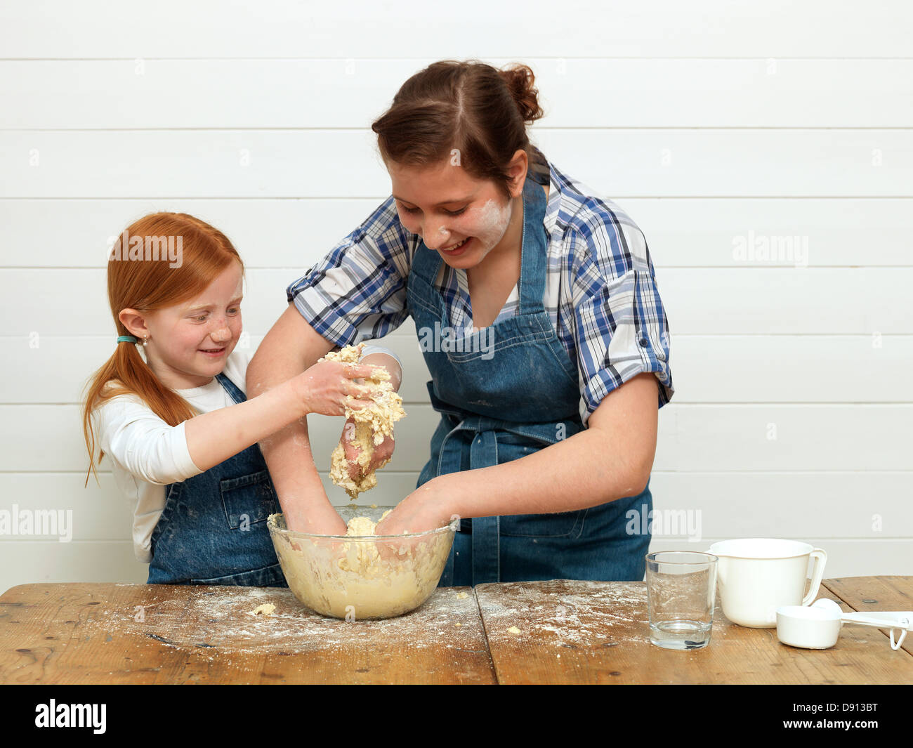 Two girls baking cake in kitchen Stock Photo - Alamy