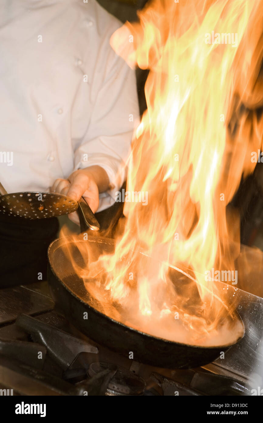 A cook preparing food in a restaurant kitchen Stock Photo - Alamy