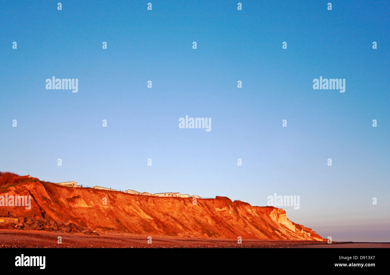 A view of the cliffs in early morning light with caravans on top at ...