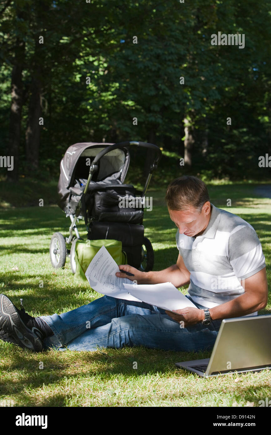 A man with a pram and a computer in a park a sunny day, Sweden Stock ...