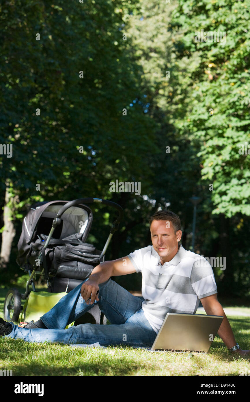 A man with a pram and a computer in a park a sunny day, Sweden Stock ...