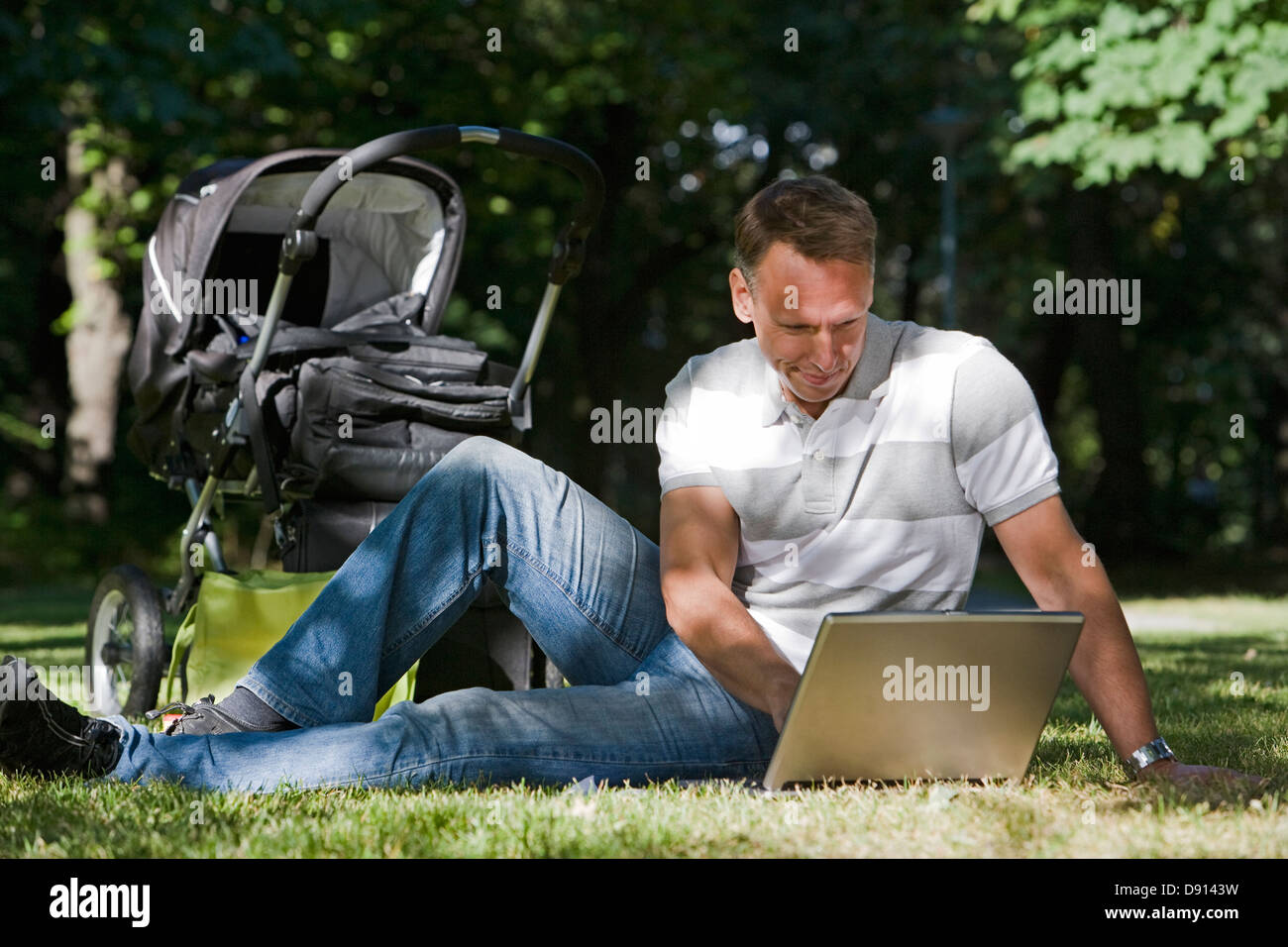 A man with a pram and a computer in a park a sunny day, Sweden Stock ...