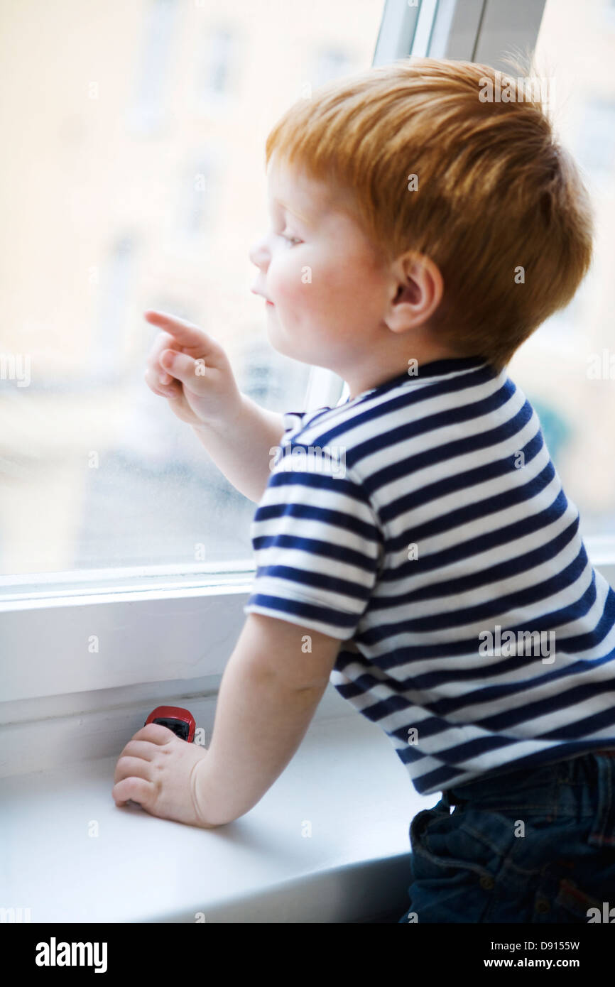 Child looking through a window, Sweden Stock Photo - Alamy