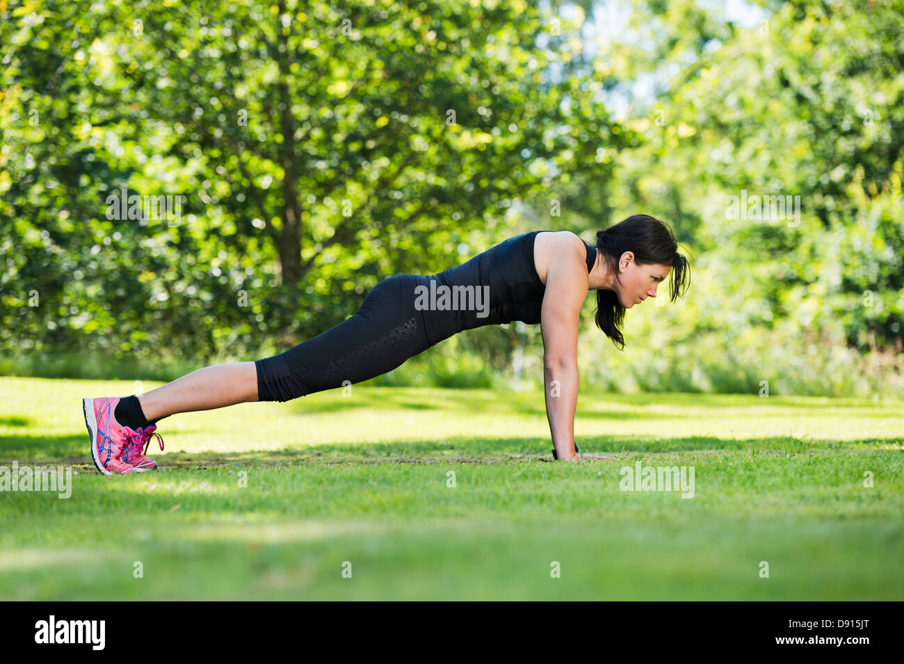Woman doing push-ups in garden Stock Photo - Alamy