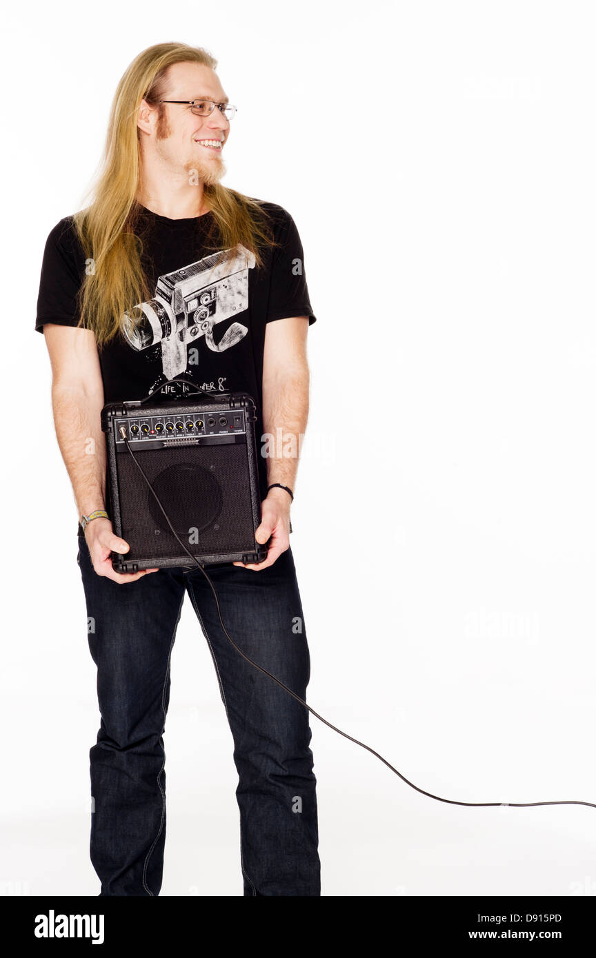 Smiling man holding amplifier Stock Photo - Alamy