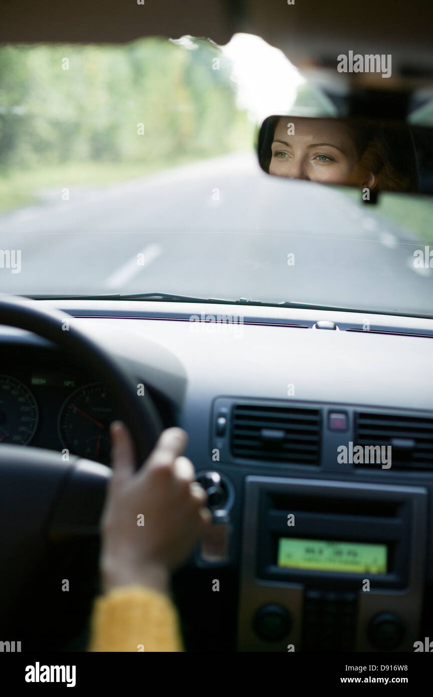 Young woman driving car reflecting in rear view mirror Stock Photo - Alamy