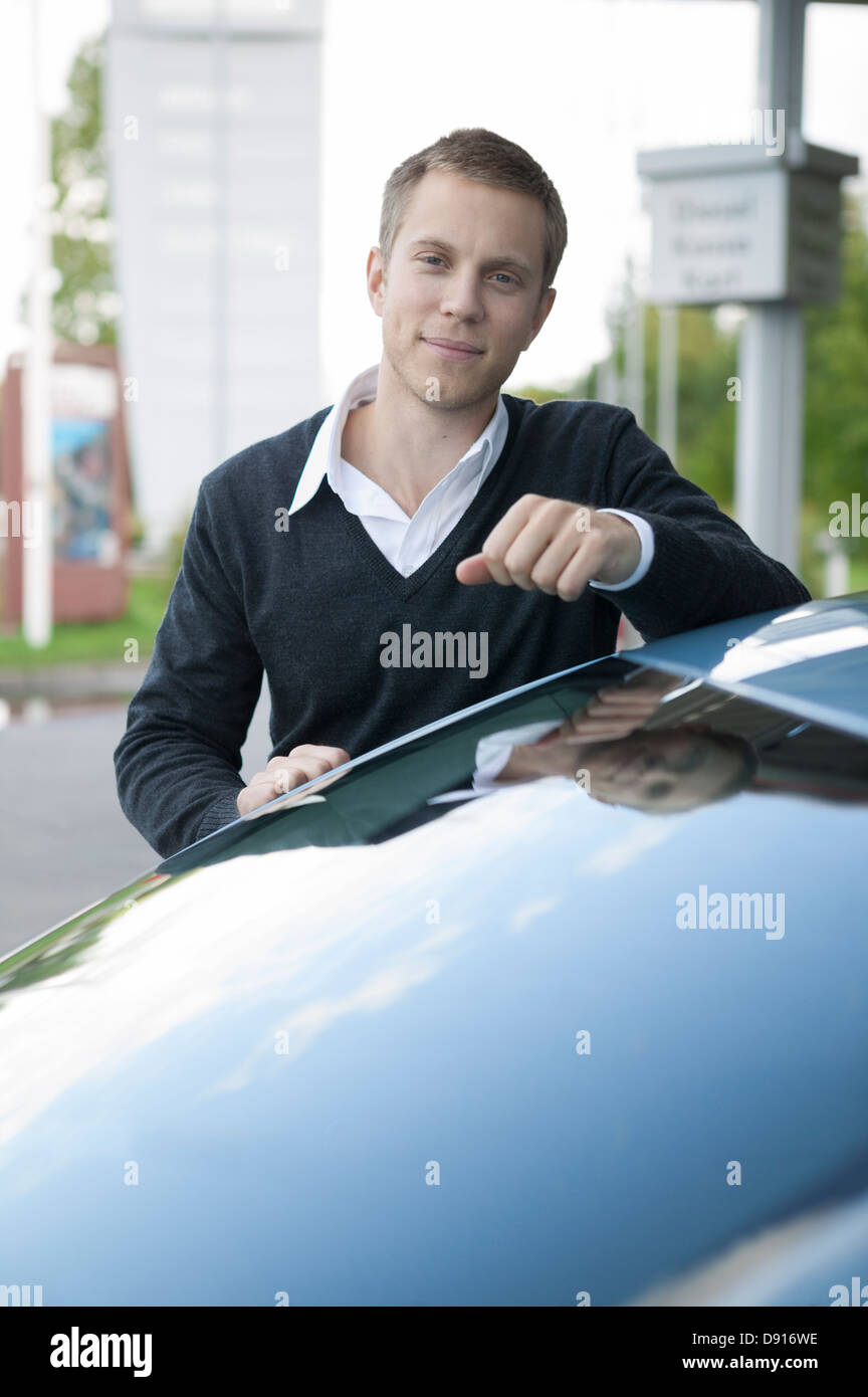Smiling young man standing near car Stock Photo - Alamy