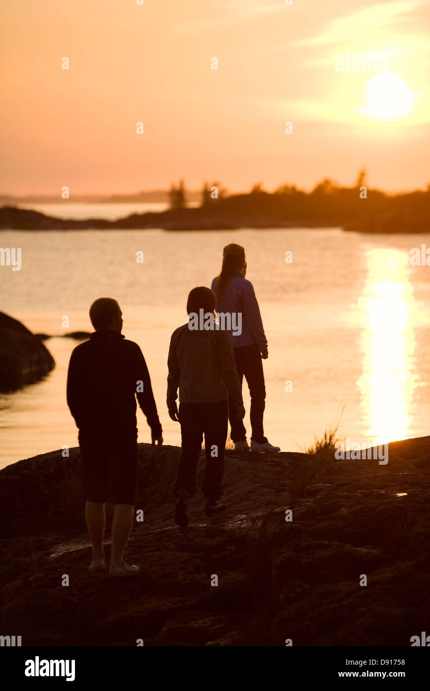 Three persons by the sea a summer night, Sweden Stock Photo - Alamy